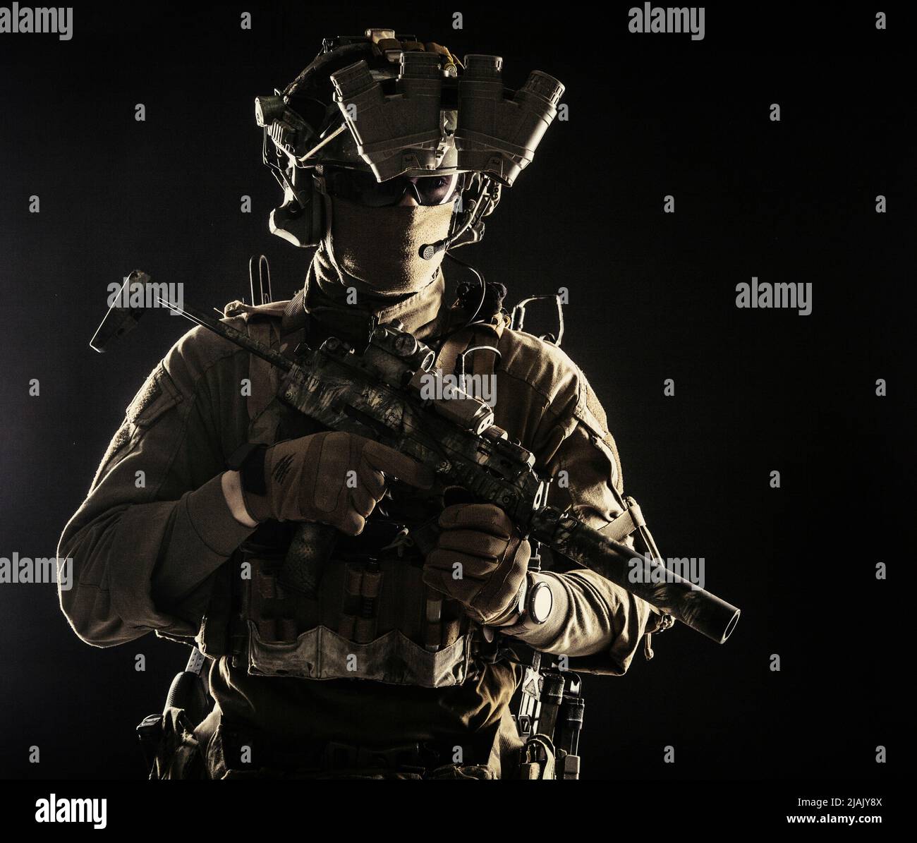 Serviceman equipped with modern weapons, studio portrait on black ...
