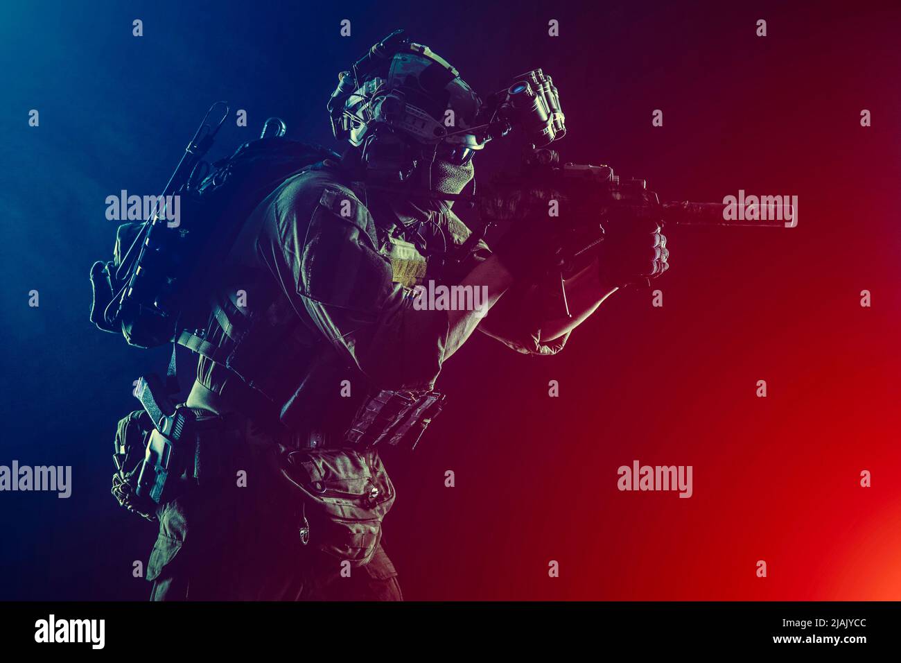A special operations soldier wearing night vision device, aiming short ...