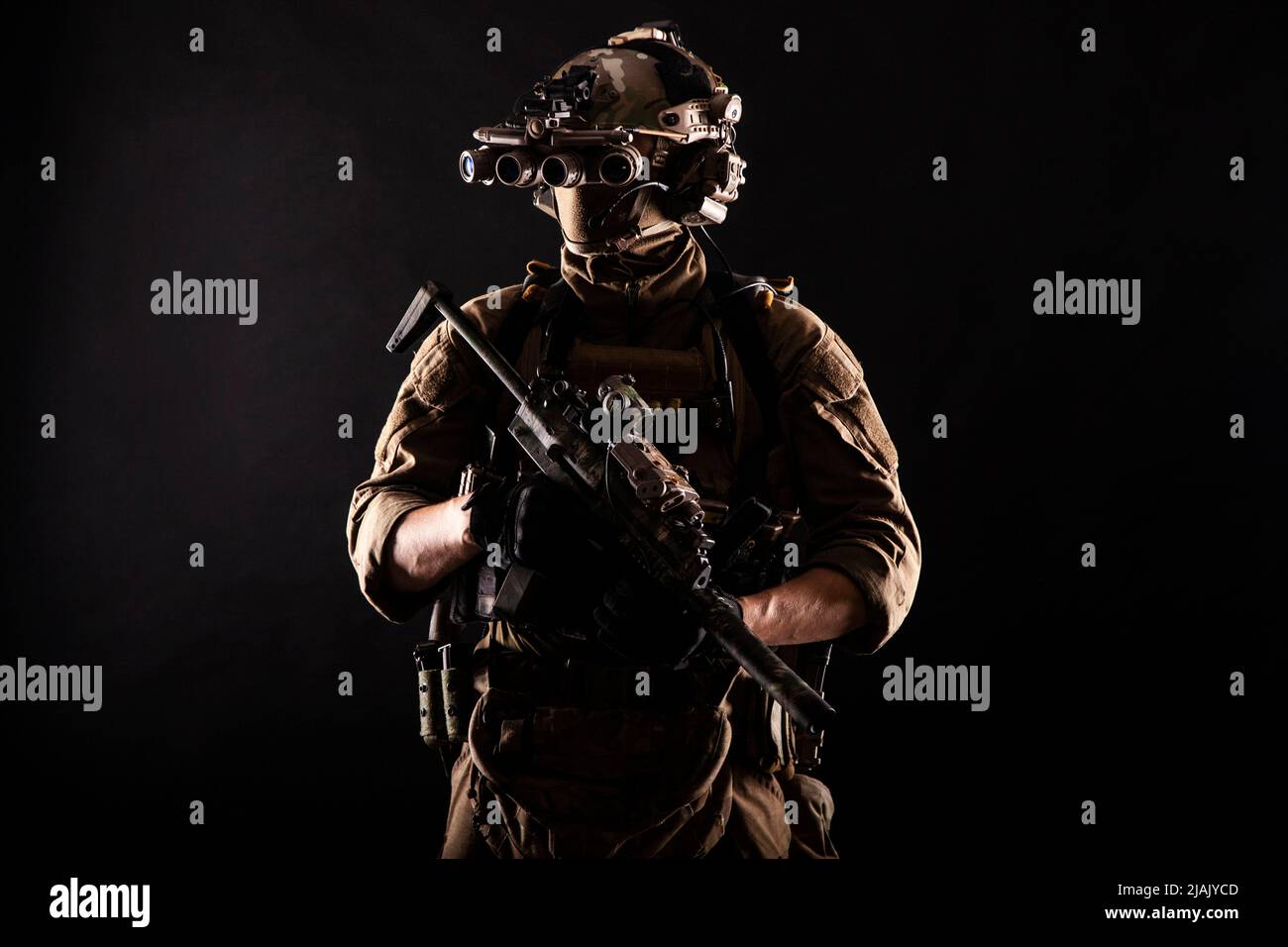 Elite soldier wearing face mask and night vision goggles, armed with ...