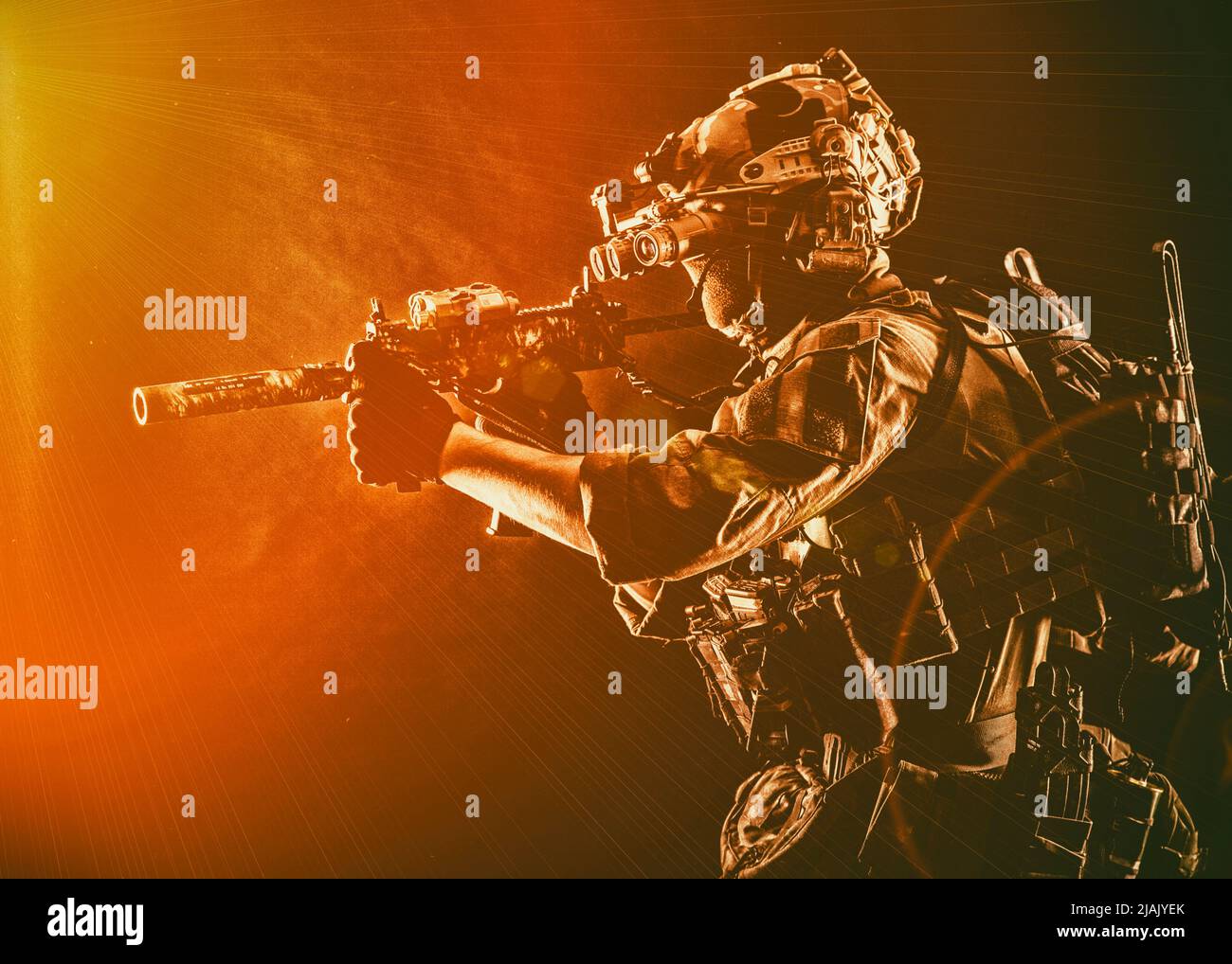 A special operations soldier wearing night vision device, aiming short ...