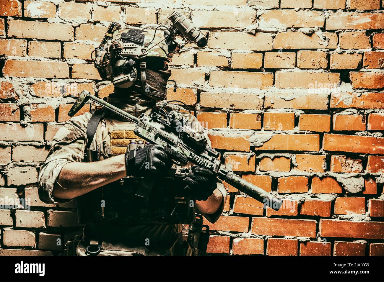 An elite soldier holding a shotgun against a brick wall, wearing face ...