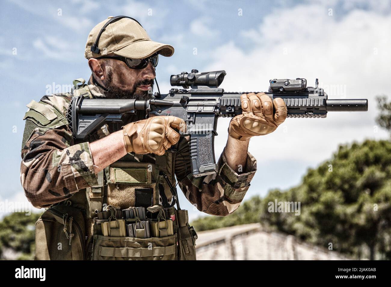 Private military company mercenary in battle uniform, holding service ...
