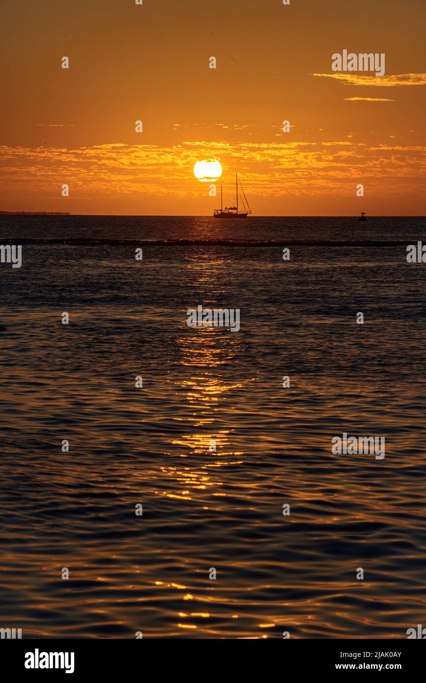 Sunset with large yellow sun under the sea surface. Calm ocean with ...