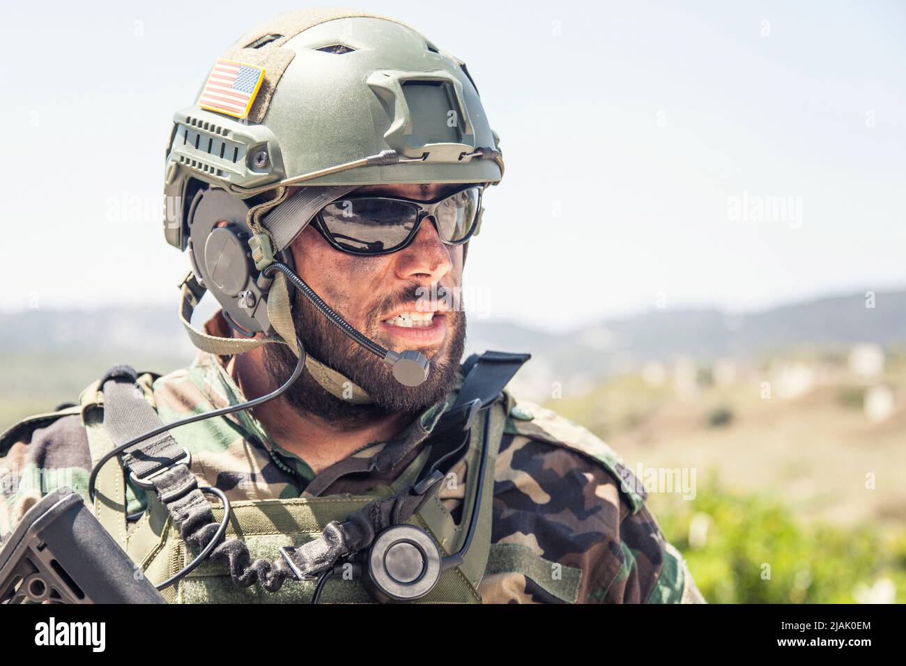 Modern warfare combatant talking into tactical radio headset during a ...
