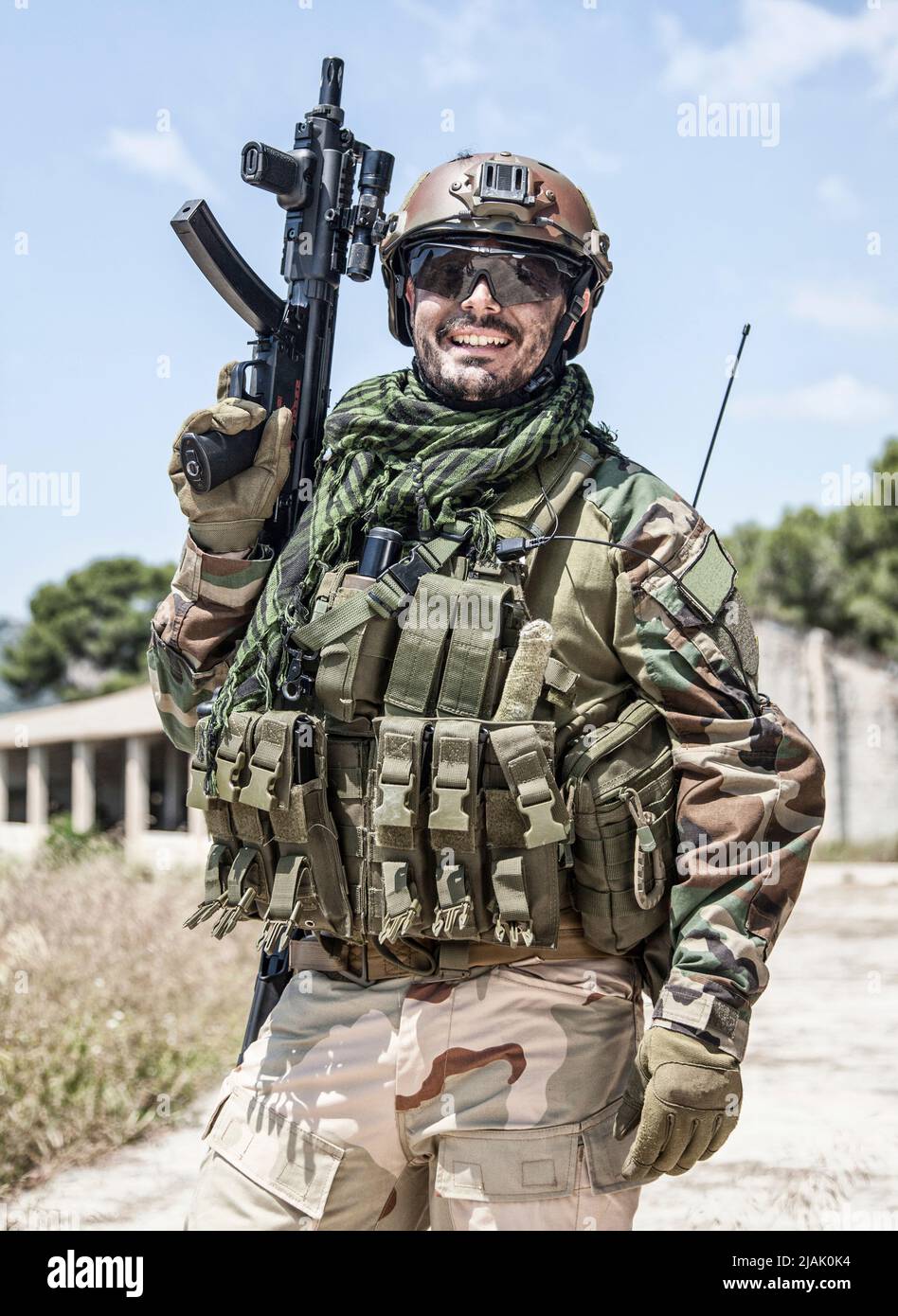 Half-length portrait of a smiling soldier armed with a submachine gun ...