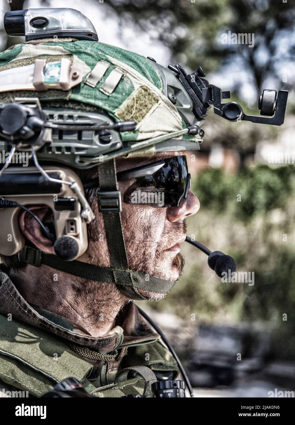 Modern warfare combatant talking into tactical radio headset during a ...