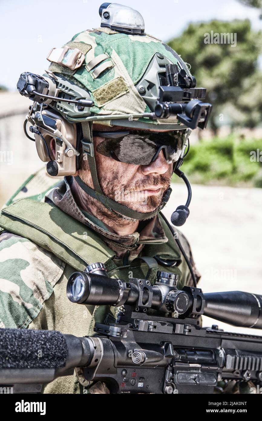 Modern warfare combatant talking into tactical radio headset during a ...