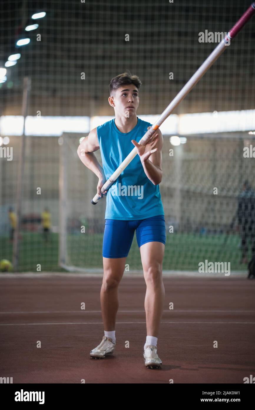 Pole vault training in the sports stadium - young man standing on the ...
