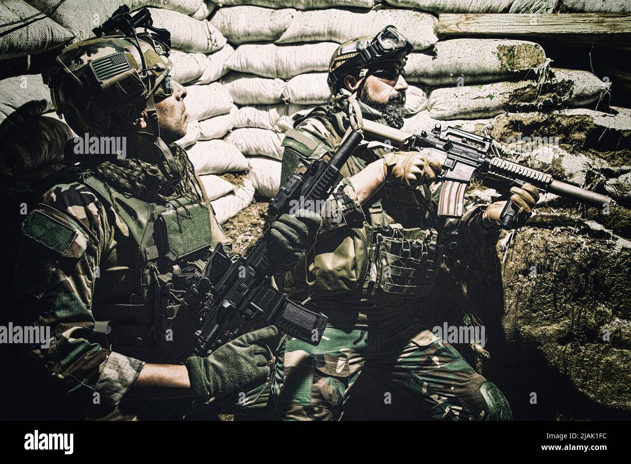 Soldiers take cover in a trench from enemy fire during a night attack ...