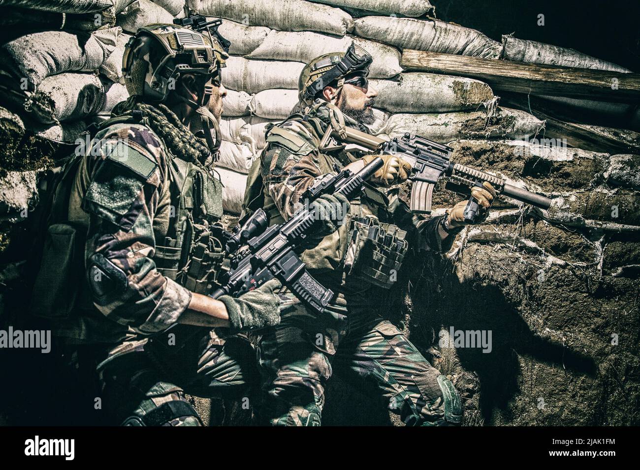 Soldiers take cover in a trench from enemy fire during a night attack ...