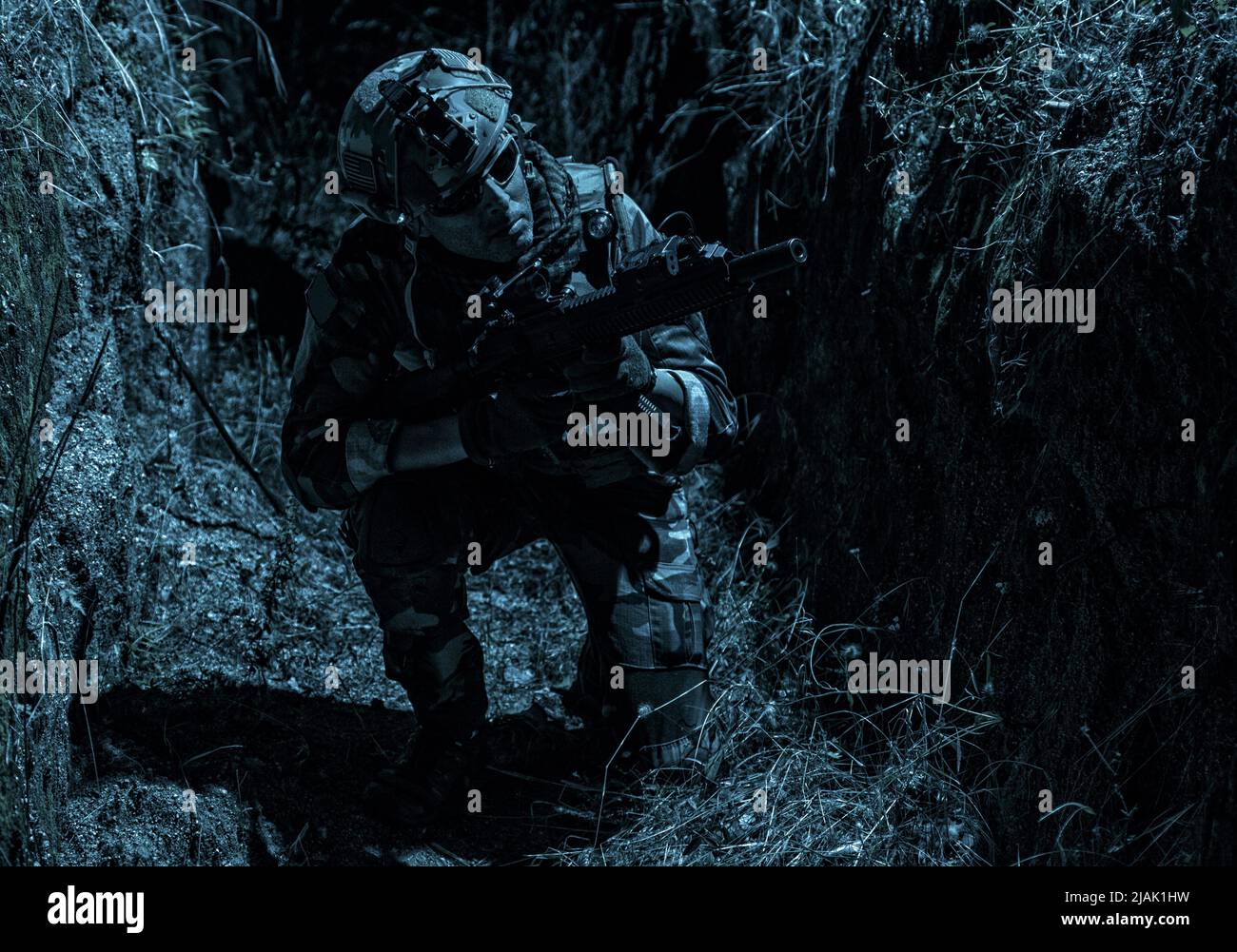 Combatant hiding from enemy fire in a trench at night Stock Photo - Alamy