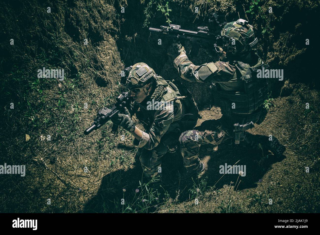 Soldiers covering each other while moving in a trench on battlefield at ...
