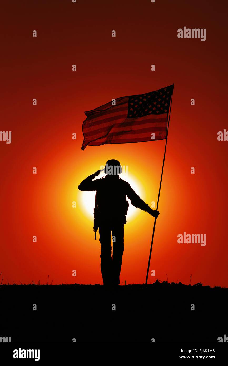 Silhouette of a soldier giving hand salute while holding American flag ...