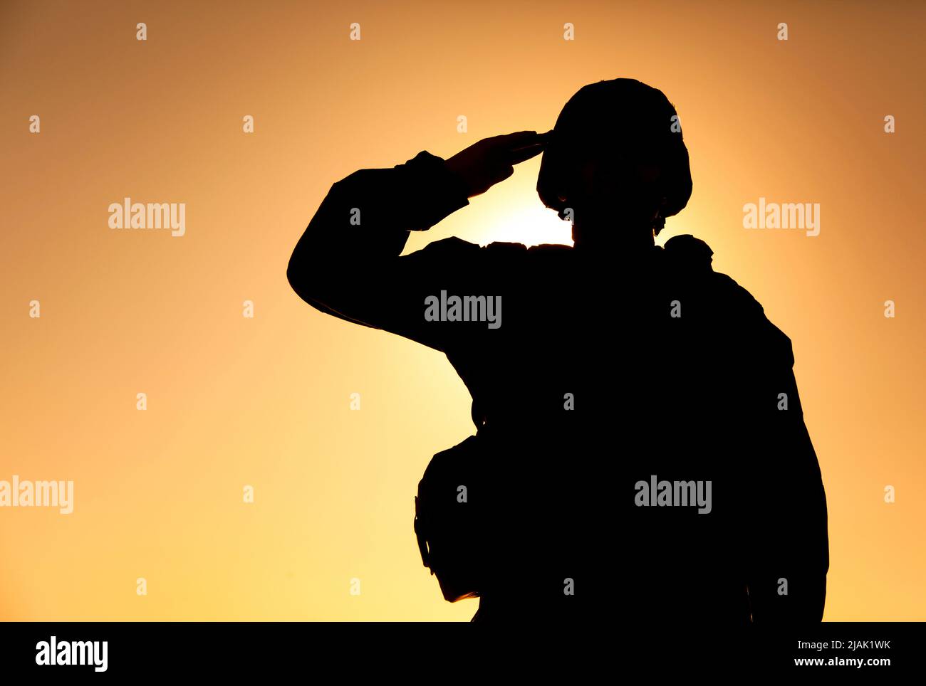 Silhouette of a soldier giving hand salute, with sunset background ...