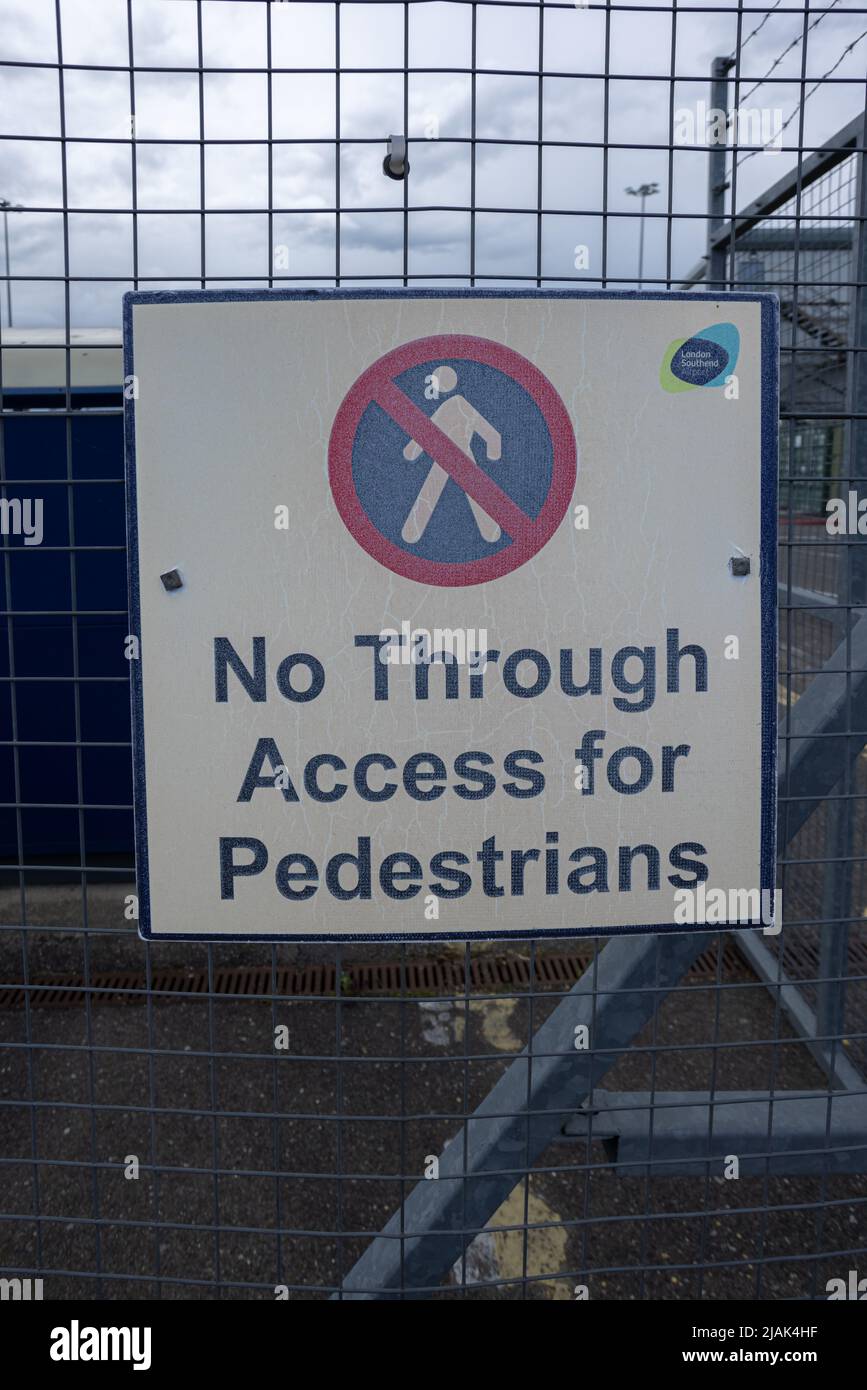 No Through access for pedestrians sign hanging on a metal fence at ...