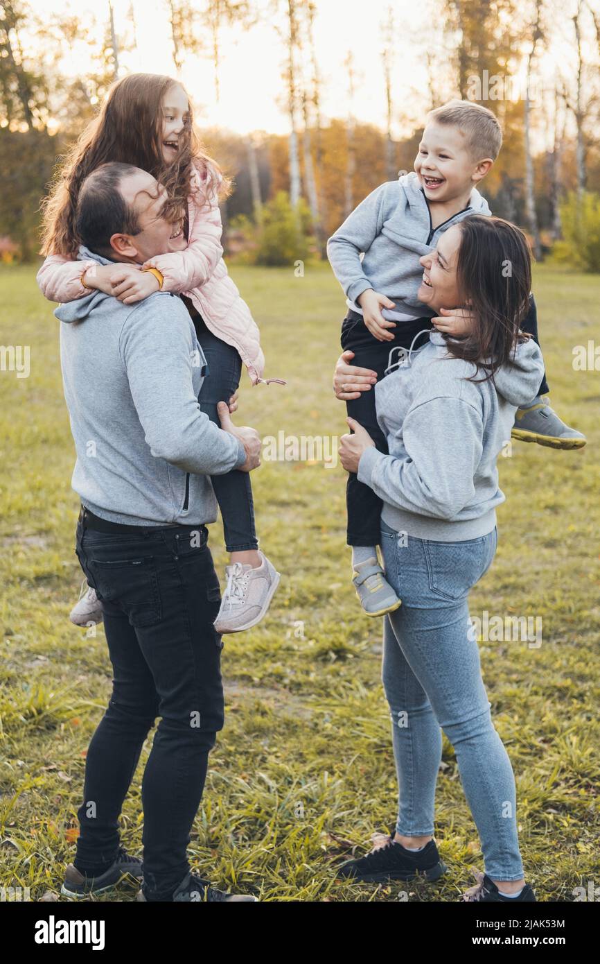 Family spending the afternoon together, parents carrying children in ...
