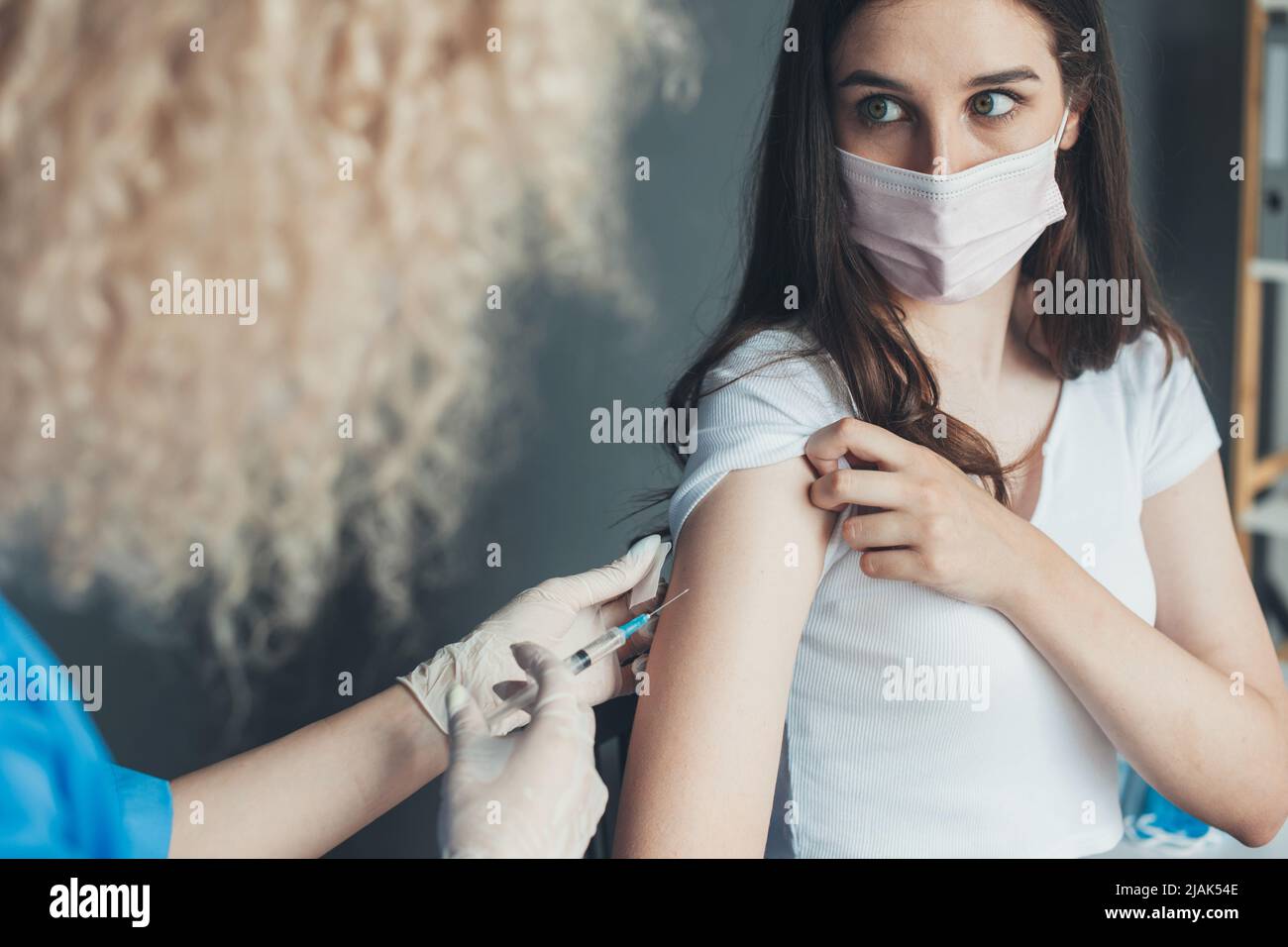 Doctor giving injection to adult woman at hospital. For medical design ...