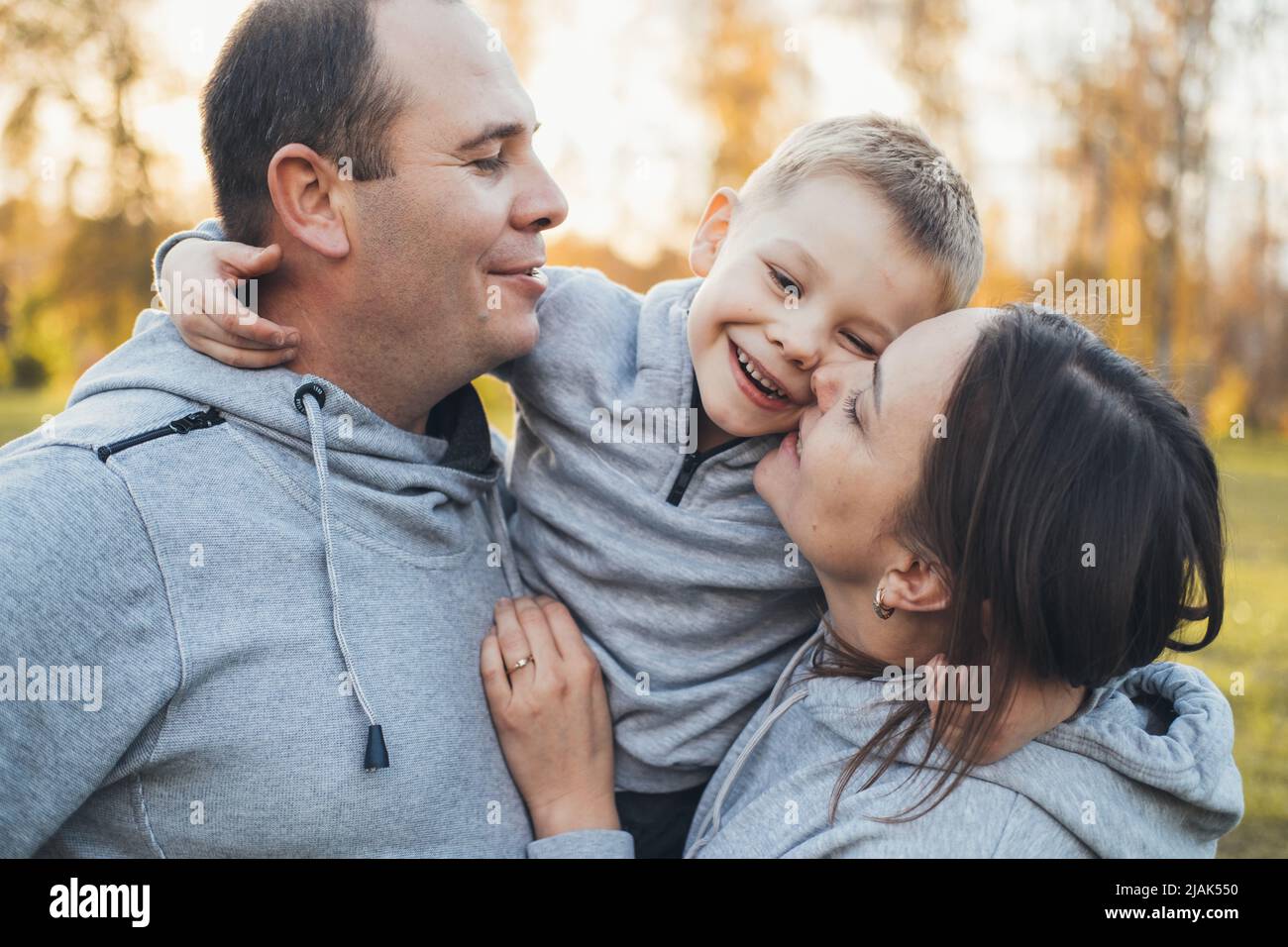 Autumn portrait with parents carrying children on shoulders. Good ...
