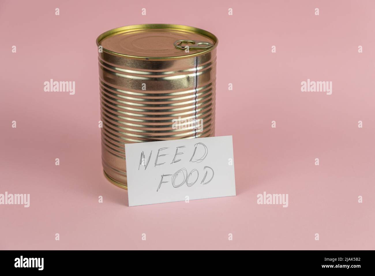 Need food. Business card with handwritten text and canned food against ...