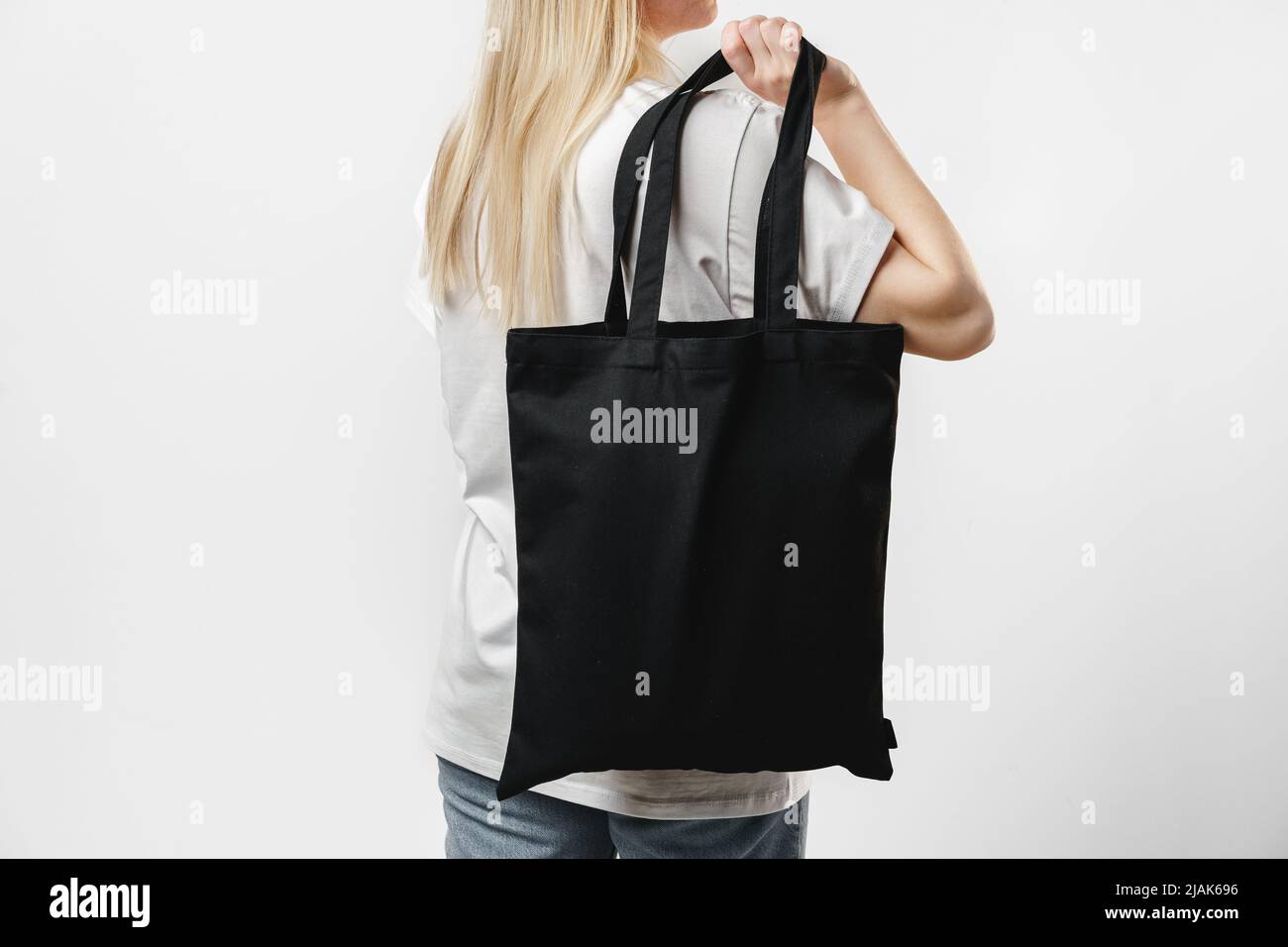 Female holding black cotton bag in her hands on white background Stock ...