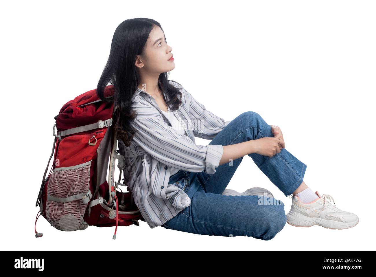 Asian woman sitting with her a backpack isolated over white background ...