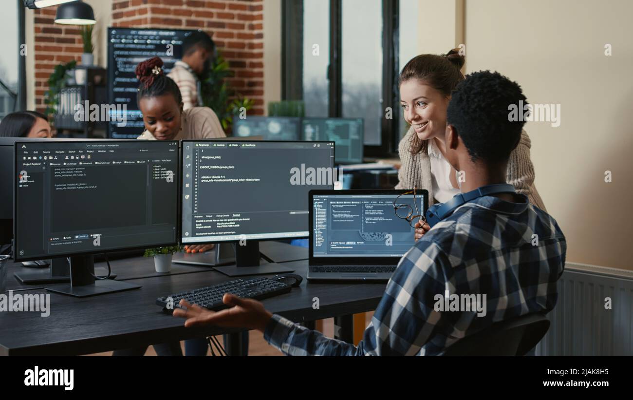 Software developers celebrating successful code compiling doing high five hand gesture with ...