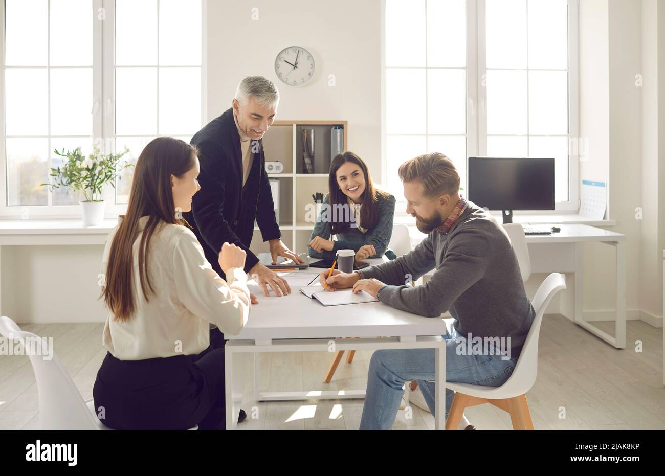 Group of positive people discuss plan for cooperation on common project ...