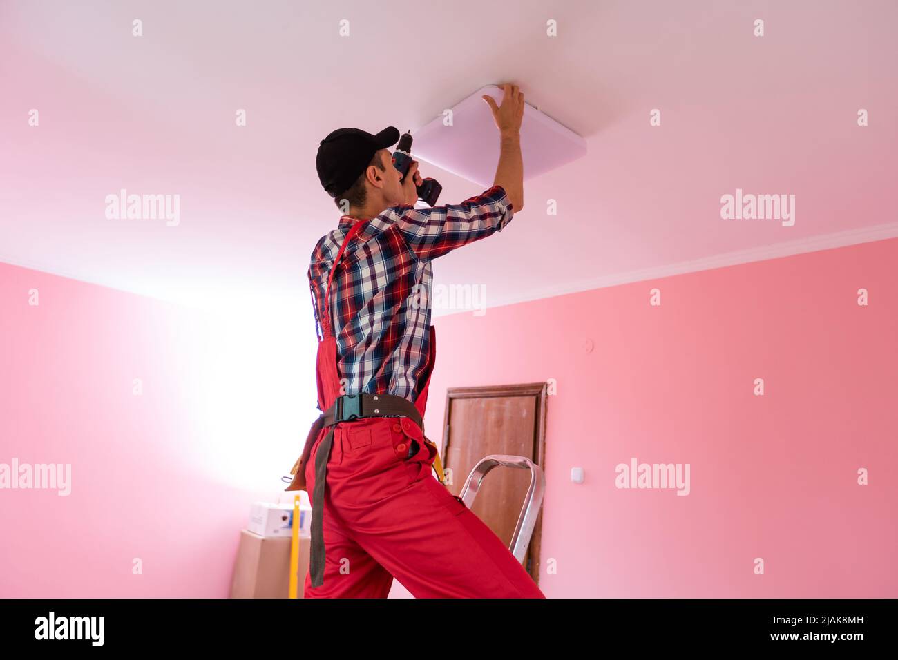Portrait Of A Male Electrician Fixing Light On Ceiling Stock Photo - Alamy