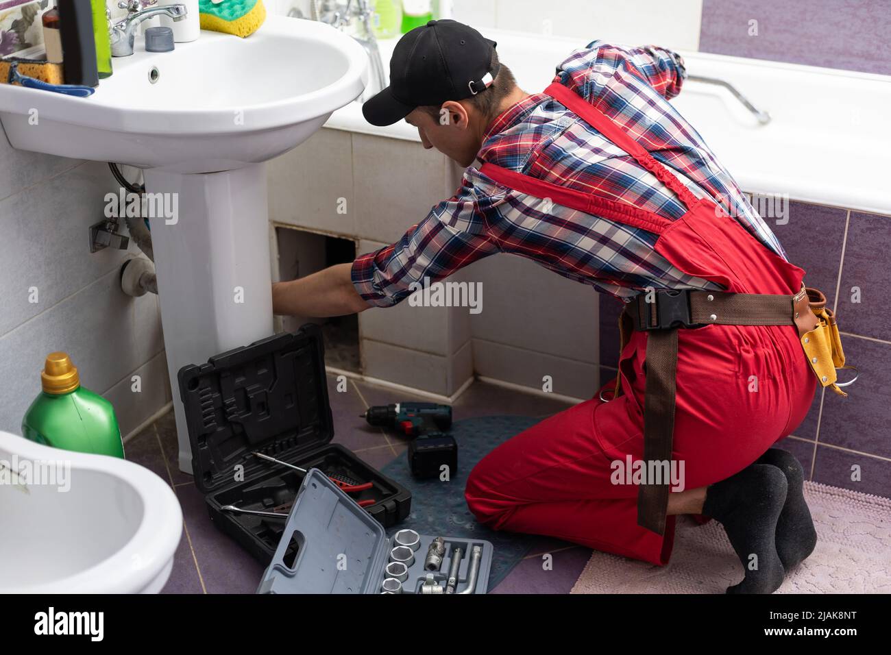 plumber at work in a bathroom, plumbing repair service, assemble and ...