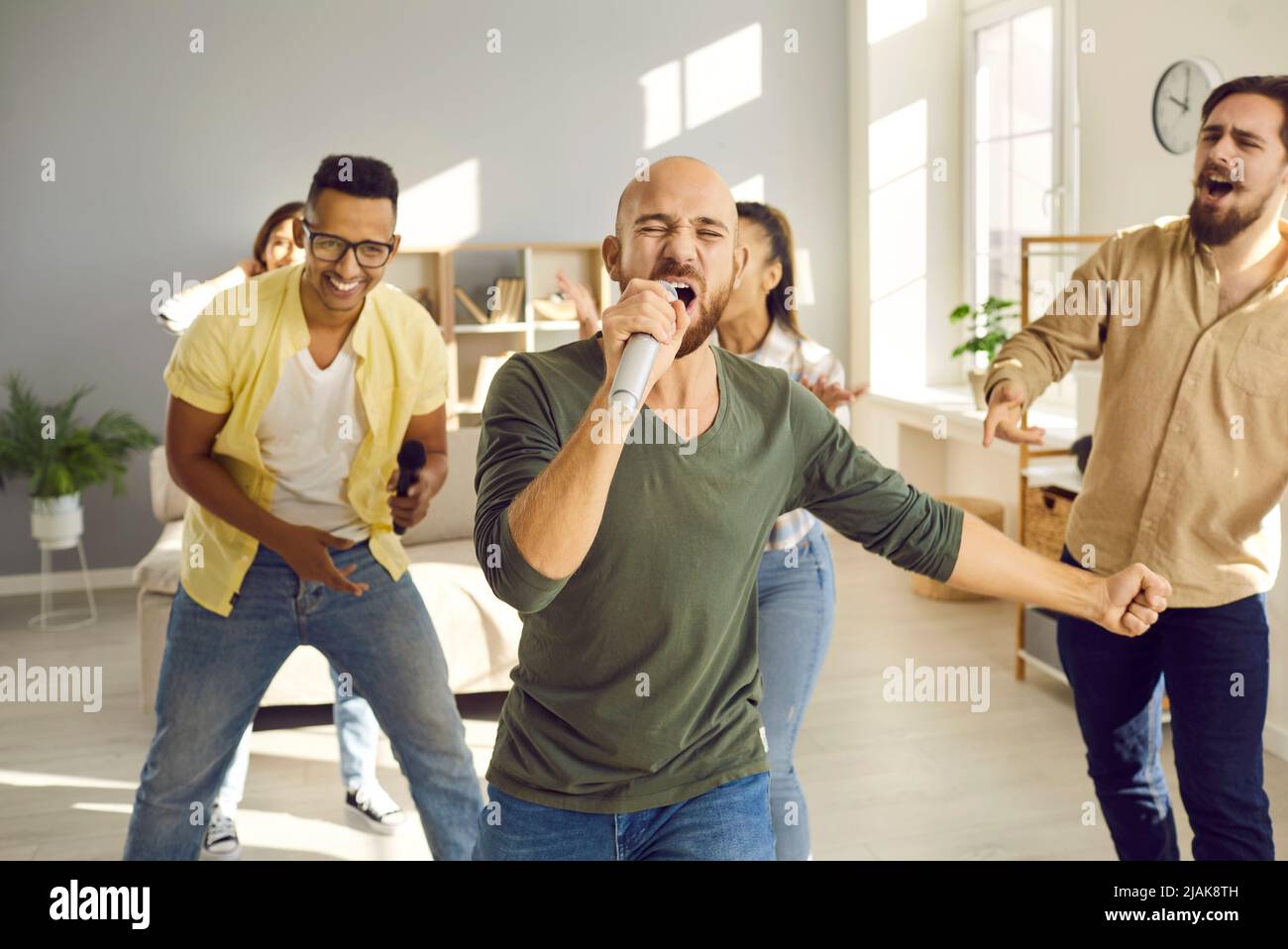 Smiling friends have fun sing karaoke Stock Photo - Alamy