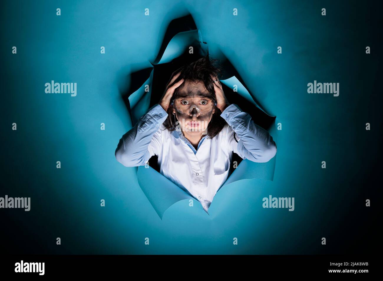 Worried crazy scientist with wacky appearance putting hands on head ...