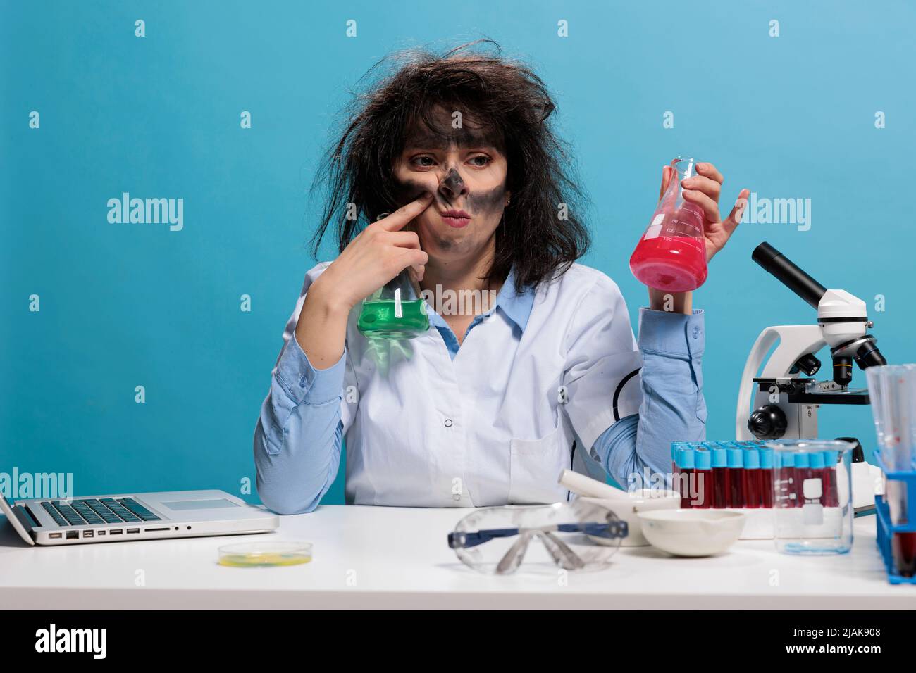 Foolish goofy looking maniac scientist having beakers filled with ...