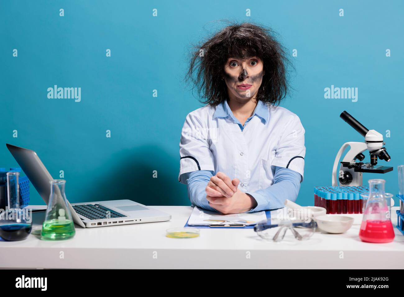 Crazy mad biochemistry expert with messy hair and dirty face sitting at ...