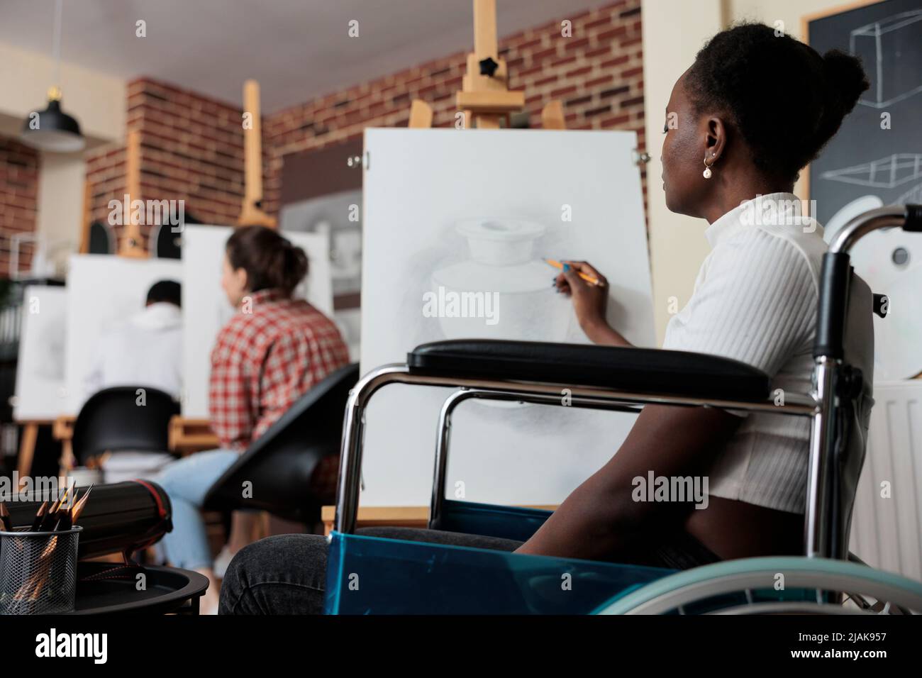 Painter student with handicap drawing vase sketch on canvas using ...