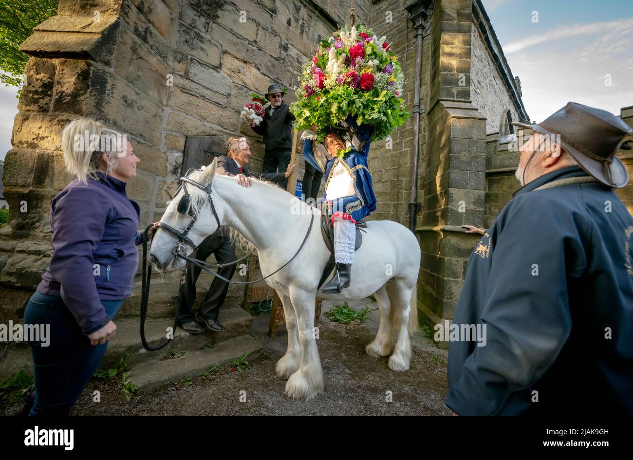 Ceremonial king, Jon Haddock, is helped to take off a large garland ...