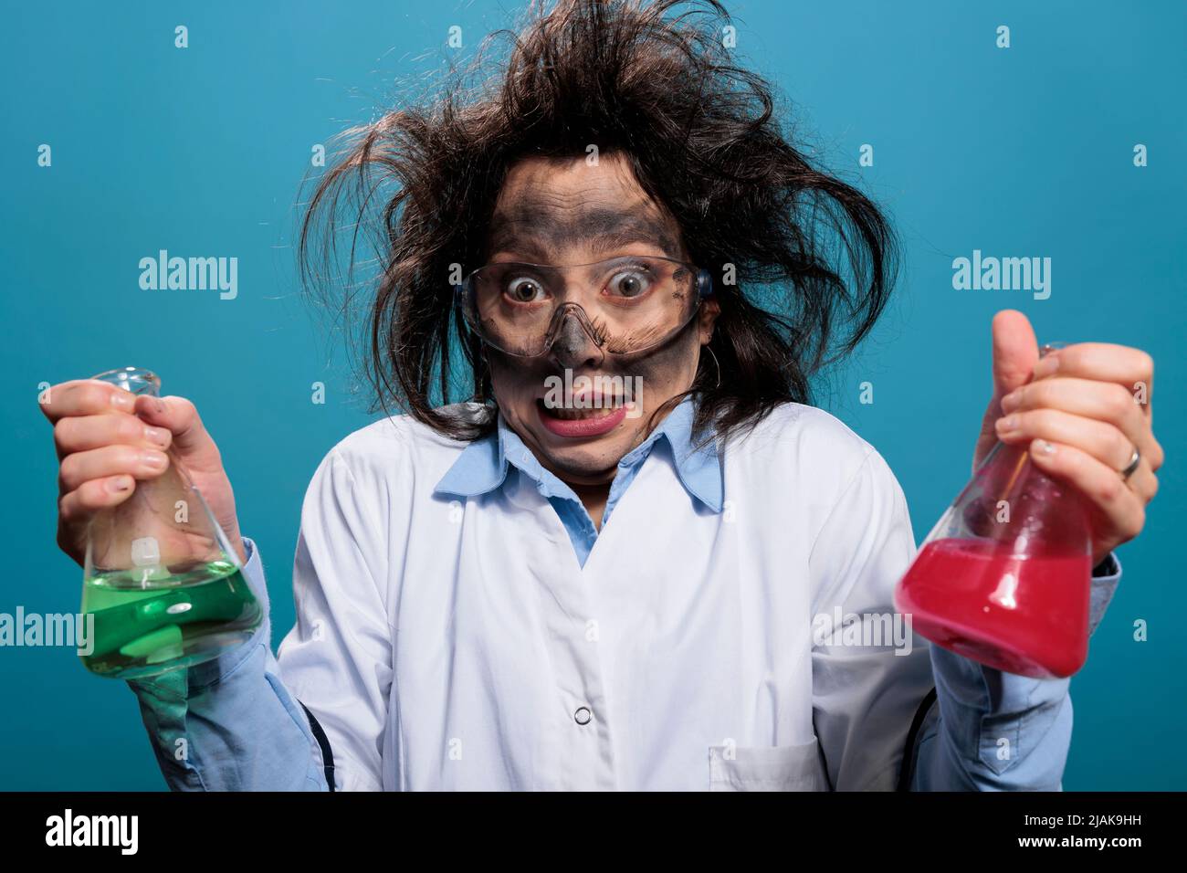 Puzzled crazy chemist having beakers filled with blood samples on blue ...
