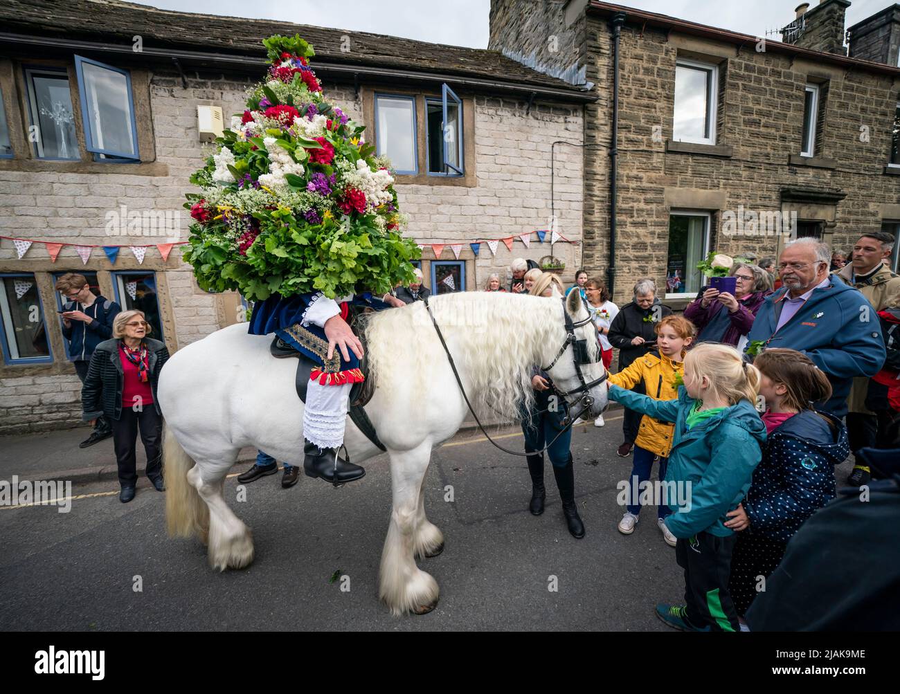 Ceremonial king, Jon Haddock, wears a large flower-covered framework ...