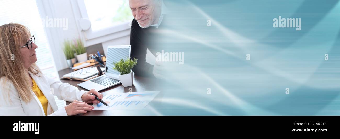 Two mature business people working together in office; panoramic banner ...
