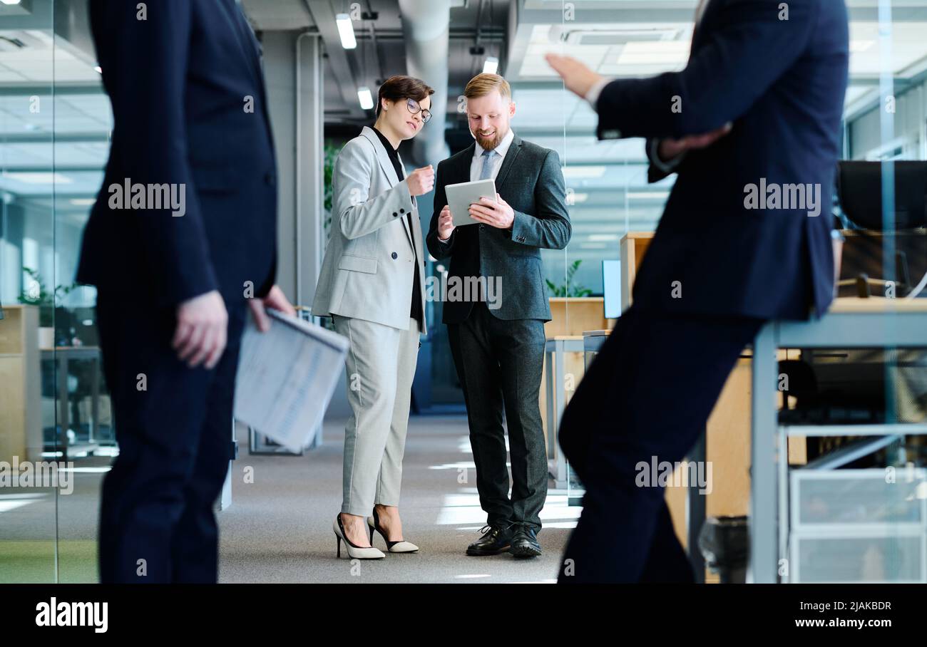 Two busness partners using tablet pc to watch online presentation and ...