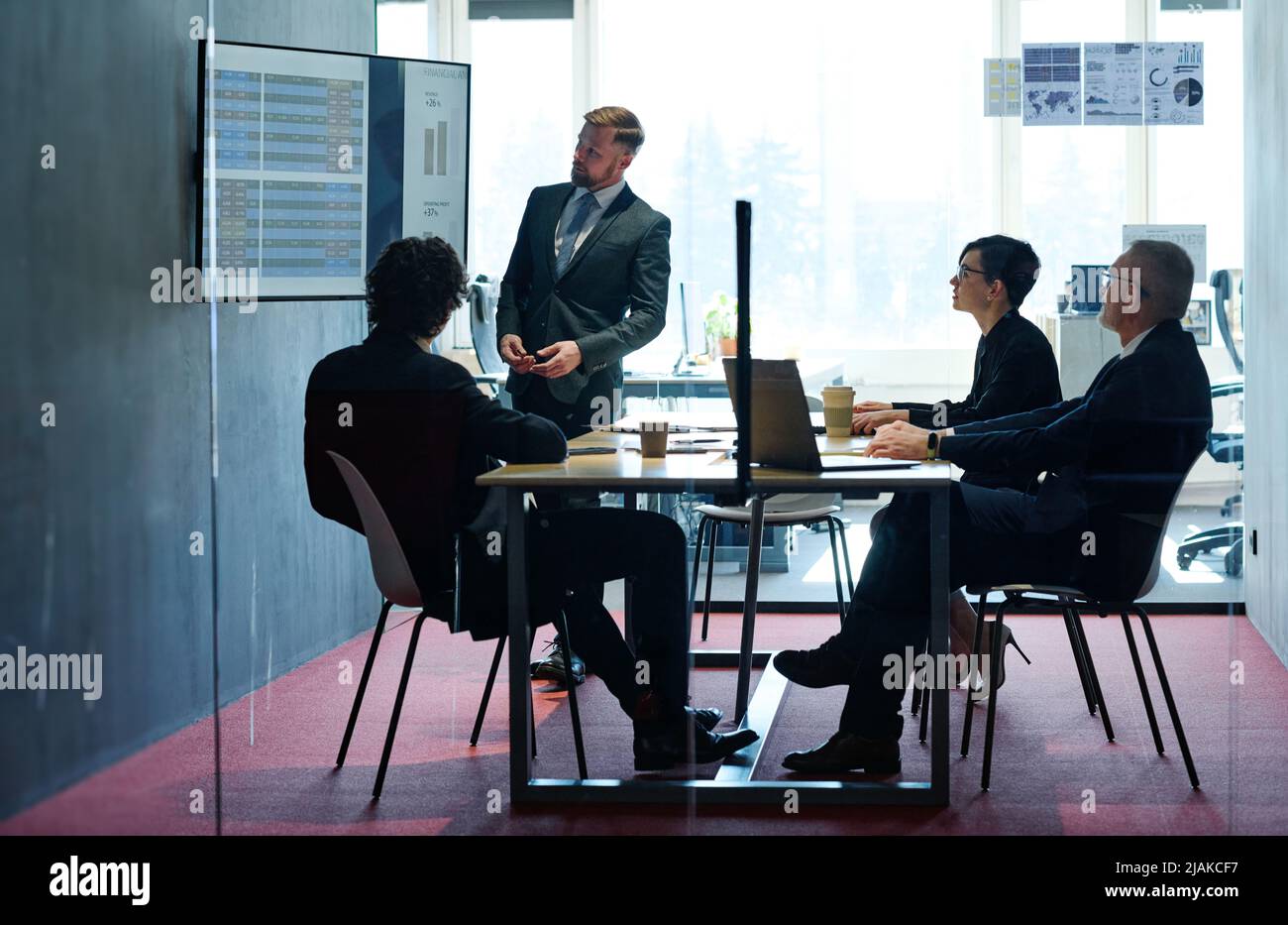 Project manager pointing at desktop presenting statistical data ...