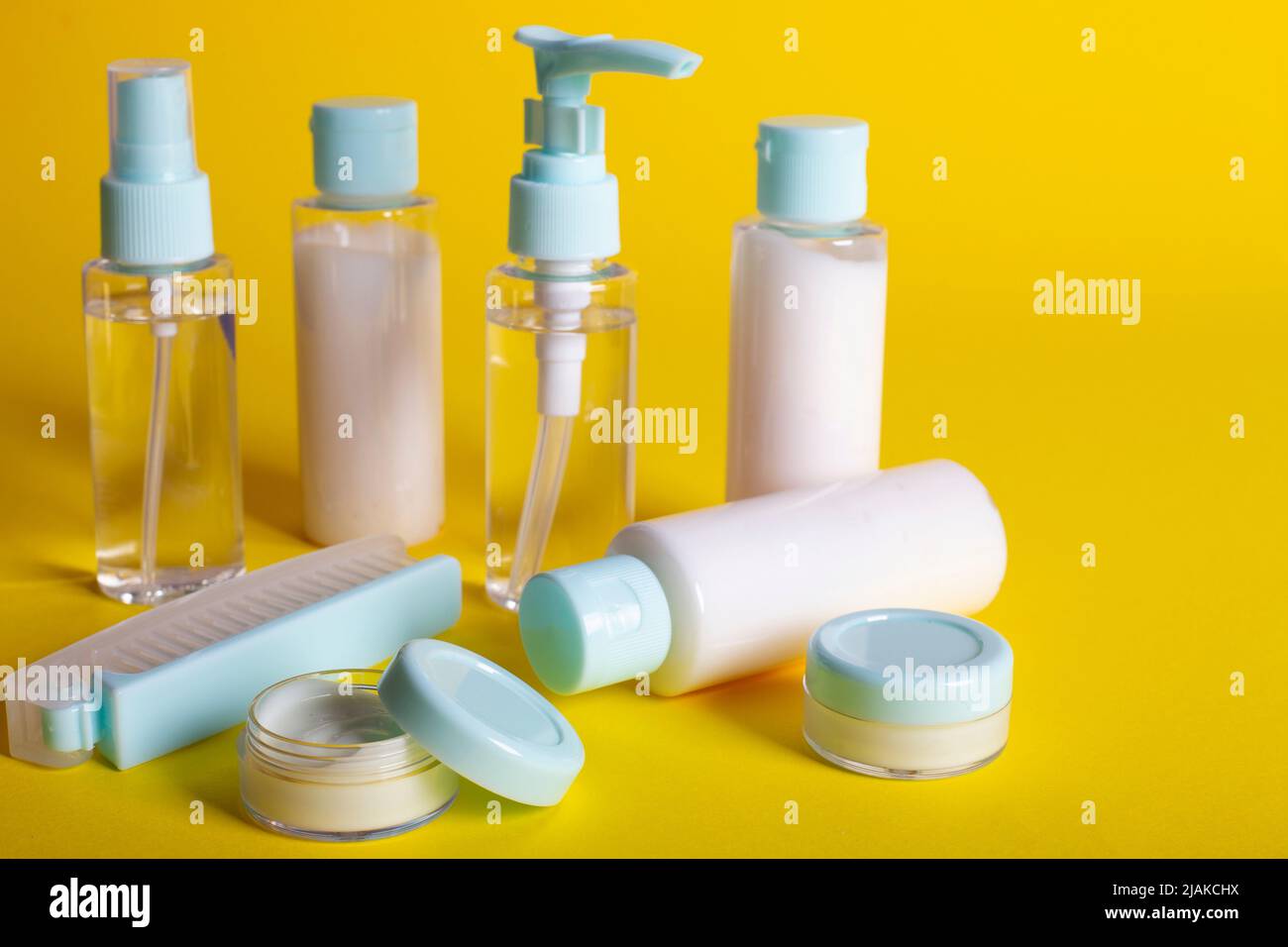 travel beauty kit on a yellow background. shampoo, balm, cream and ...