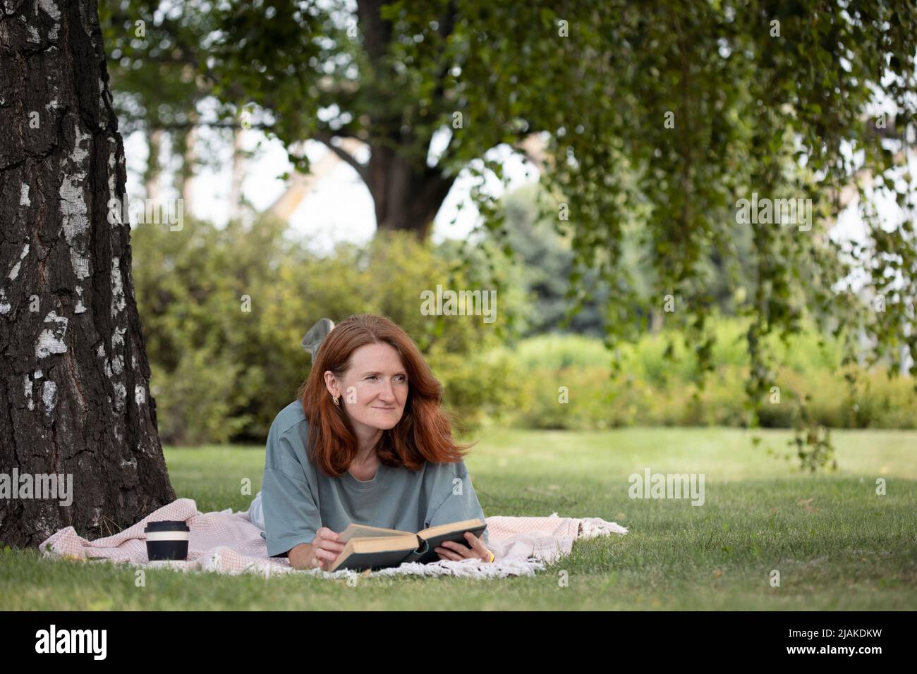 girl reading a book on the lawn Stock Photo - Alamy