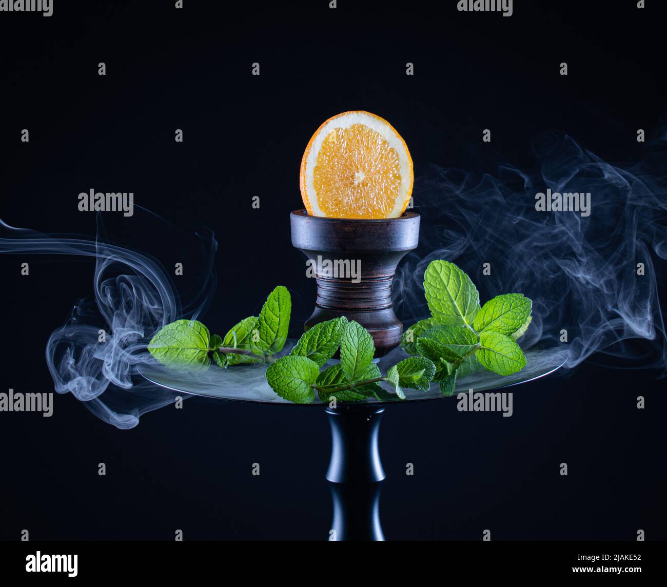fruit hookah with tobacco, orange, mint and smoke on black background ...