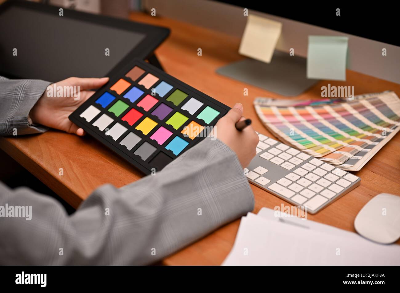 Professional female graphic designer holding a colour checker board and ...