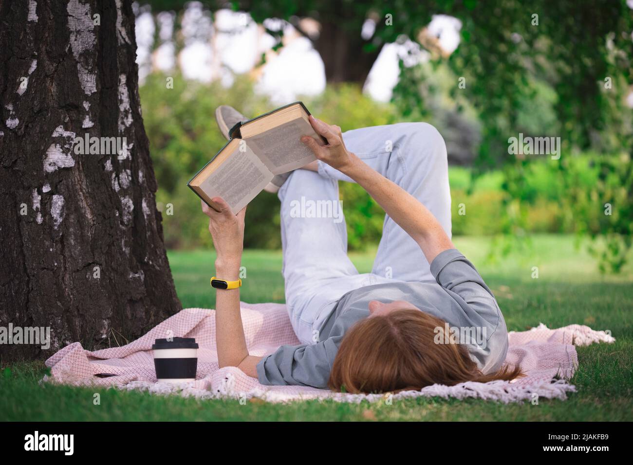 girl reading a book on the lawn Stock Photo - Alamy