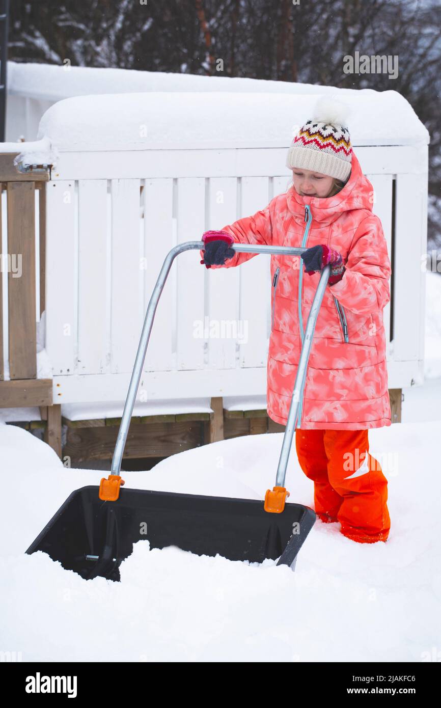 winter and snowfall. child girl cleans snow with a shovel Stock Photo ...