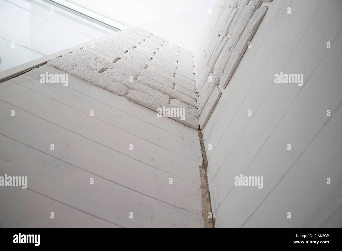 White wall made of decorative stone in the form of a brick. Laying ...