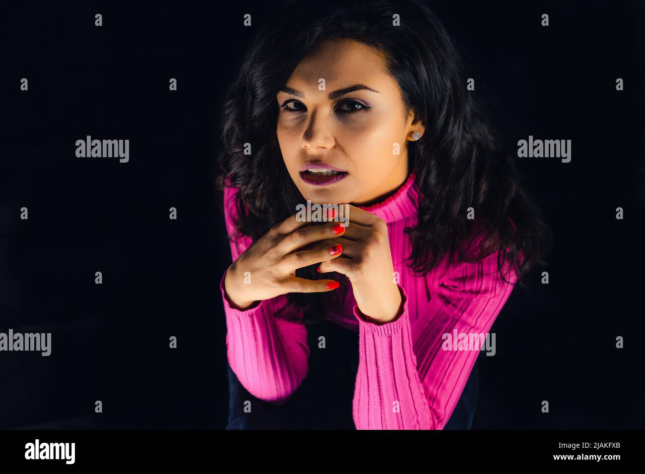 black-haired girl in her 20s with a pink blouse in the studio on a black background Stock Photo ...