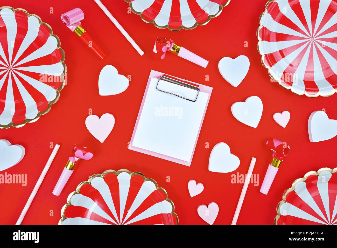 Party flat lay with paper plates, heart ornaments, candy and drinking ...
