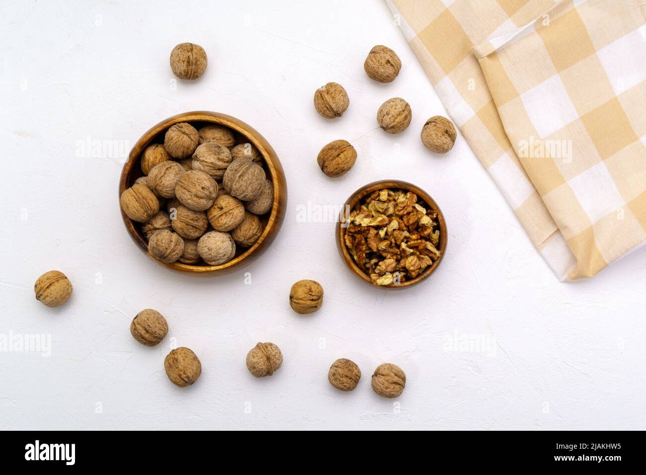 Walnuts in a wooden bowl on a white background with a copy space. View ...